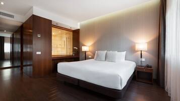 Quarto de hotel moderno com uma cama grande, piso de madeira e um guarda-roupa embutido.