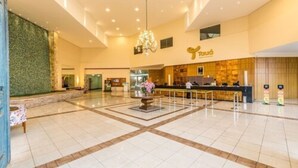 Um amplo hall de entrada com uma recepção, um candelabro e uma fonte decorativa.