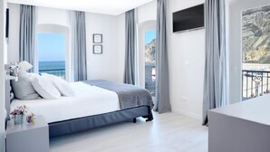 Quarto moderno com cama, mesa de cabeceira e televisão.