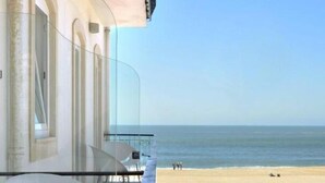 Hotel à beira-mar com varanda de vidro com vista para o mar.
