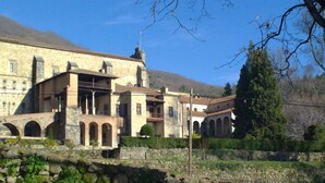 Um edifício de pedra com várias arcadas e um amplo pátio central.
