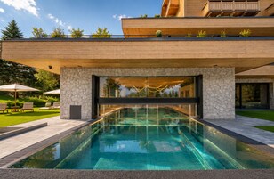 Uma casa moderna com piscina, paredes de pedra e deck de madeira.