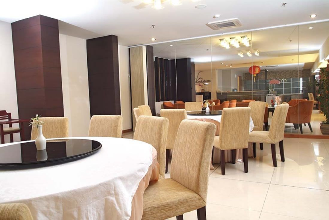 Uma sala de jantar moderna com uma mesa redonda e cadeiras bege estofadas.