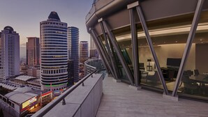 Hotel moderno com fachada de vidro, proporcionando vistas panorâmicas da cidade.