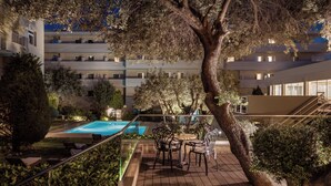 Terraço no telhado com piscina, área de estar ao ar livre e vista para um edifício.