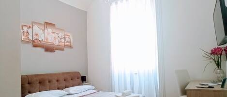 Quarto com cama grande, escrivaninha e cadeira.