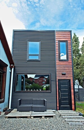 Um edifício moderno com uma janela grande e uma porta preta.
