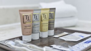 Uma bandeja com quatro frascos de produtos de higiene pessoal rotulados 'Tobi Tobi' sobre uma superfície de madeira.