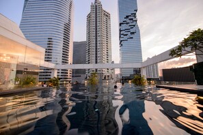 Uma área de piscina urbana moderna, com edifícios altos ao fundo.