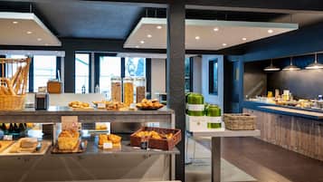Uma área de buffet de café da manhã com diversas opções de comida e um espaço para café.