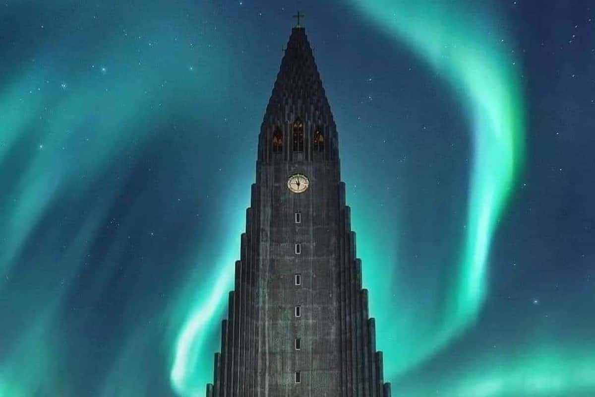 Uma igreja grande e moderna com uma torre alta e pontiaguda e um relógio no topo.