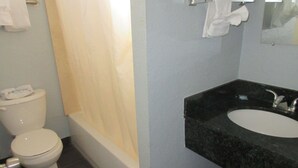 Casa de banho com sanita, lavatório e banheira.