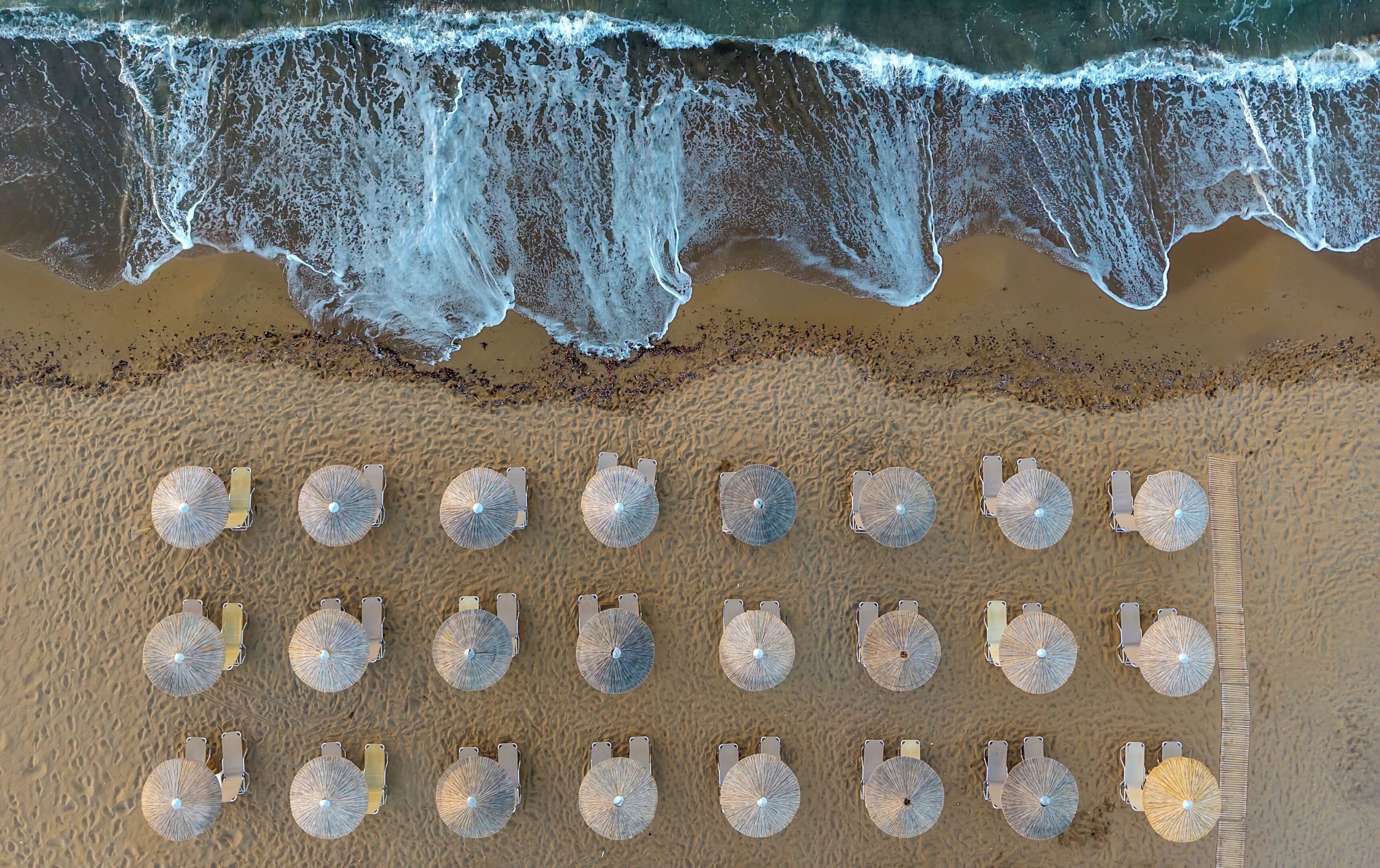 Na praia, espreguiçadeiras, guarda-sóis de praia, toalhas de praia 