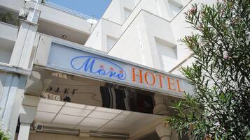 Placa de hotel com o nome "More Hotel" e vista parcial da fachada do edifício.