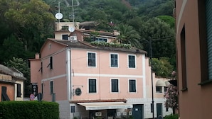 Um edifício rosa com uma placa indicando Hotel Argentina, um bar de vinhos e petiscos, e um aviso de proibido estacionar.