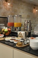 Um buffet de café da manhã com diversas opções de alimentos e bebidas.