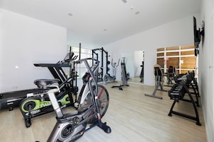 Uma academia com diversos equipamentos de exercício, incluindo esteiras, bicicletas ergométricas e aparelhos de musculação.