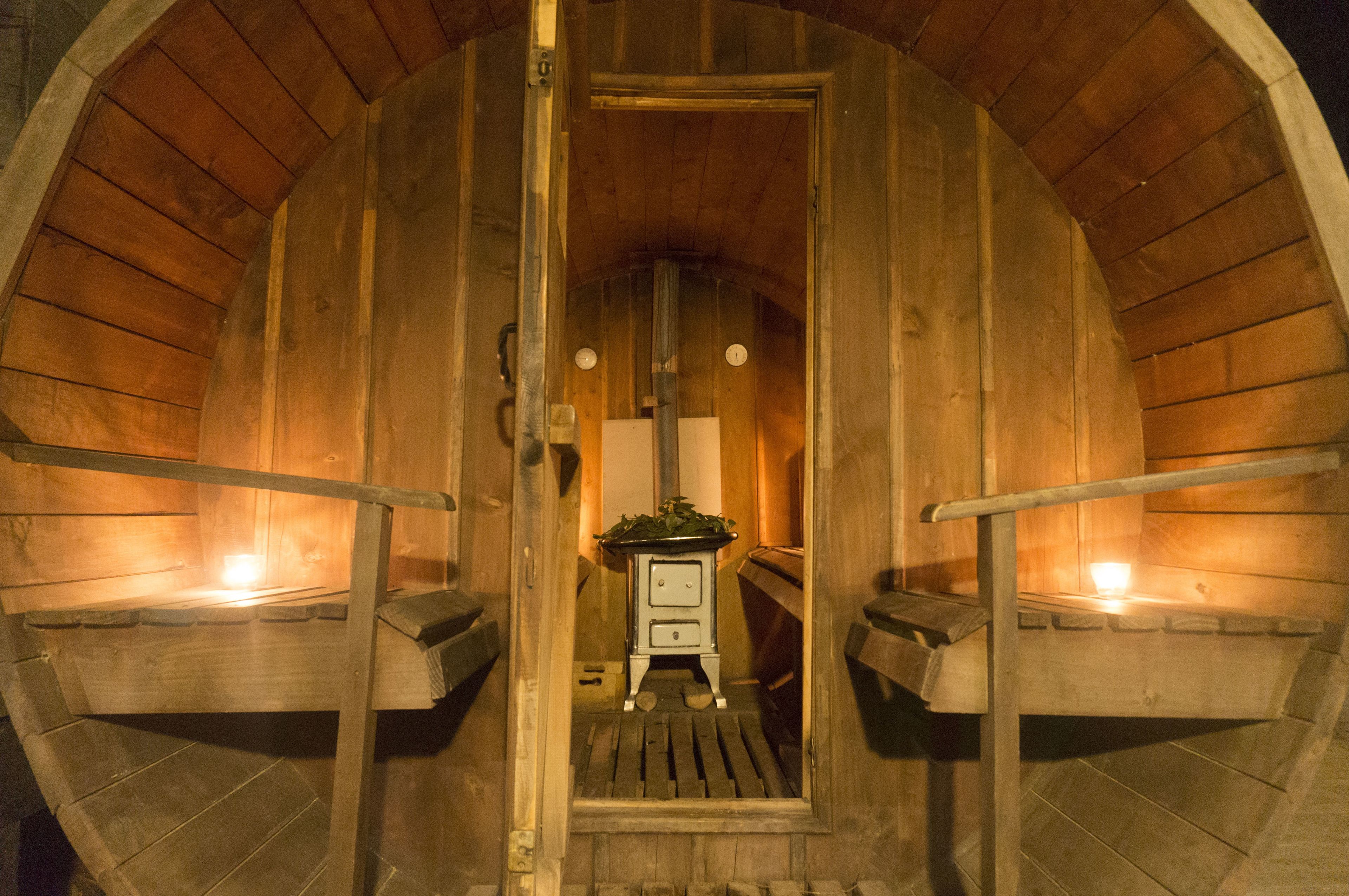 Uma sauna de madeira com um banco e uma pequena mesa no centro.