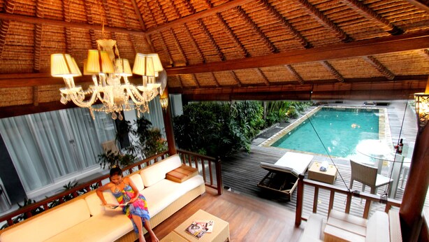 Um deck de madeira com piscina, um sofá e uma mesa.
