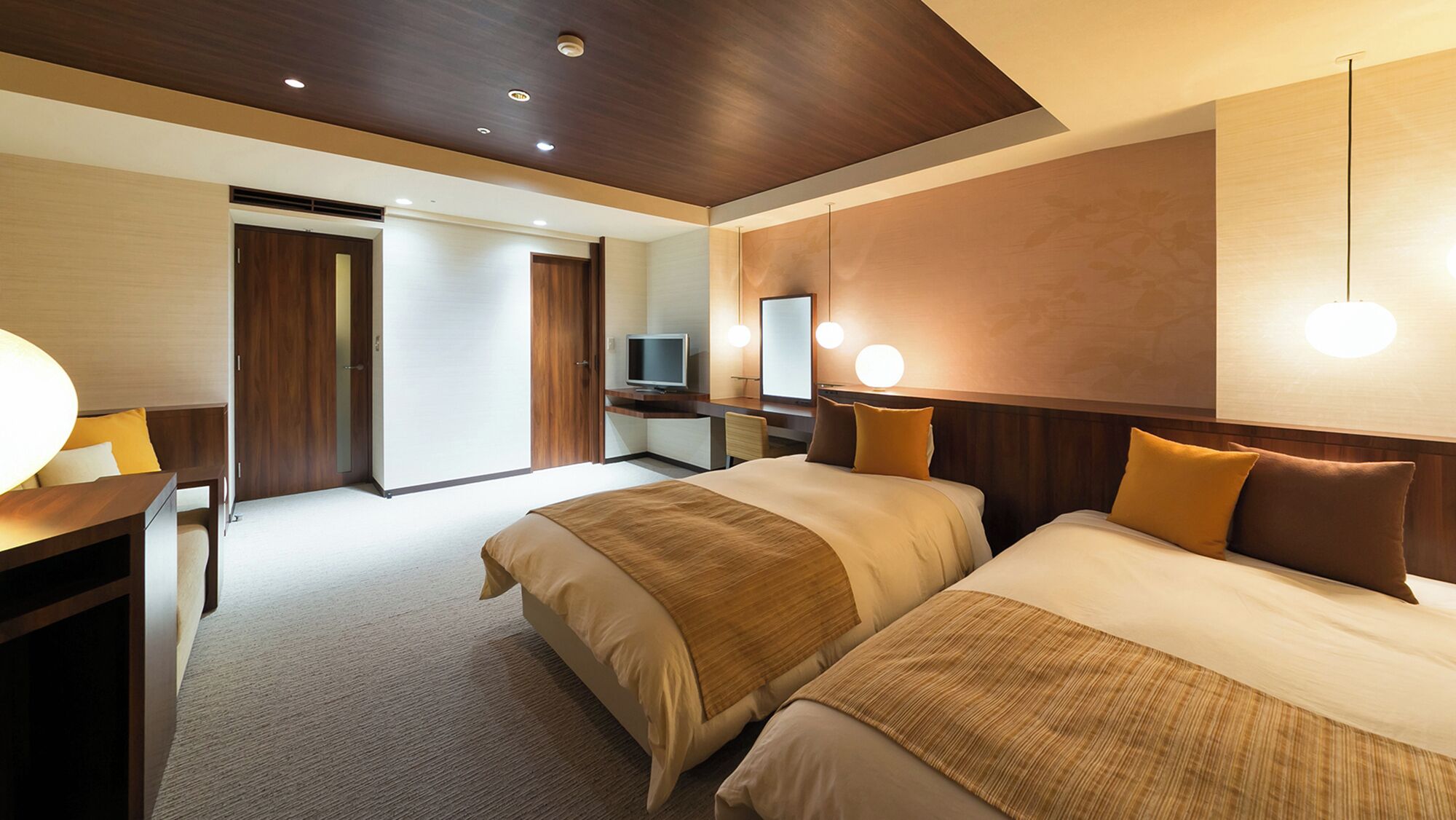 Quarto de hotel com uma cama grande, uma escrivaninha, televisão e banheiro.