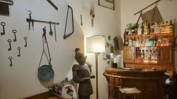 Uma área de bar com banquetas, balcão e diversas garrafas.