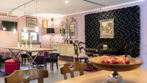 Uma sala de jantar moderna com mesa de madeira, cadeiras e uma fruteira.