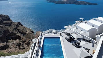 Piscina com vista para o mar e relevo rochoso.