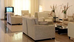 Uma sala de estar moderna com um sofá, uma mesa de centro e plantas decorativas.