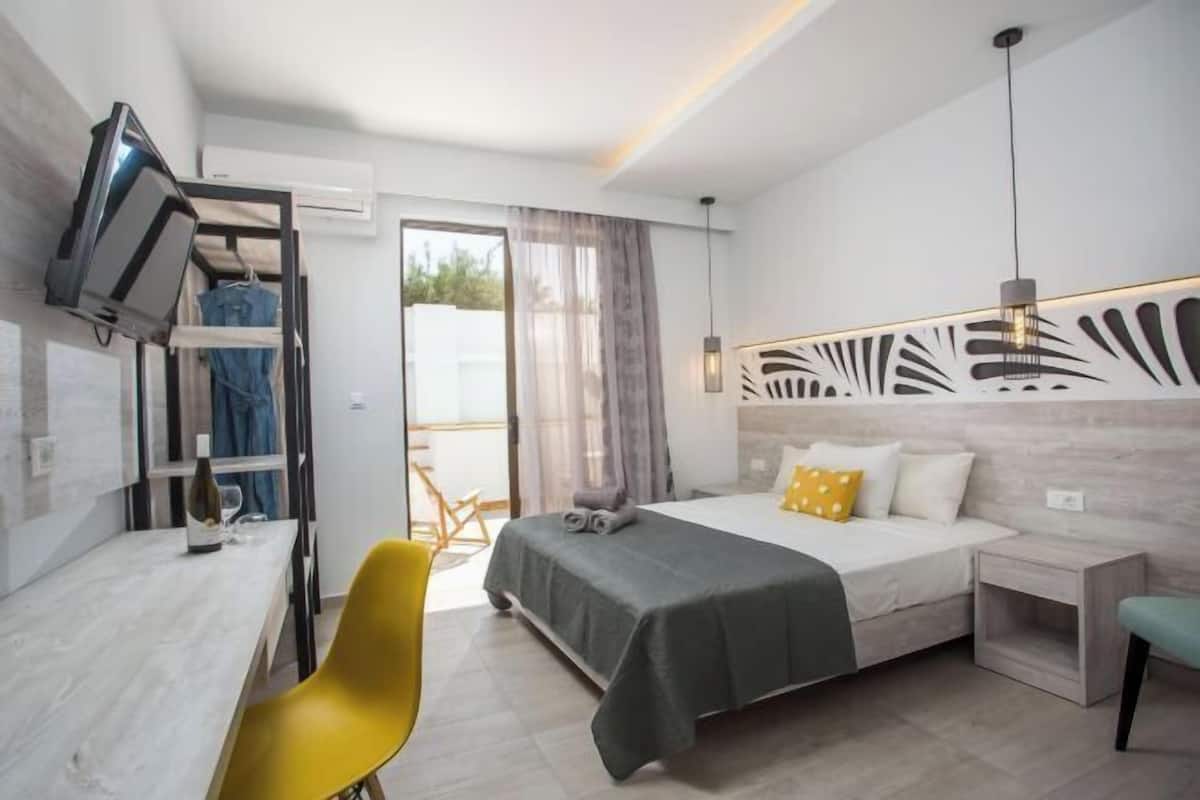 Quarto moderno com cama, mesa de cabeceira e escrivaninha com cadeira.