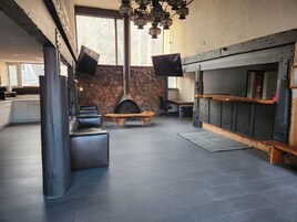 Um interior moderno com parede de pedra, lareira, assentos de couro e um banco de madeira.