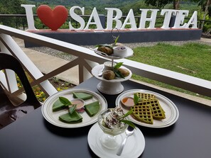 Uma mesa com diversos doces e um letreiro ao fundo com a inscrição 'I love Sabahtea'.