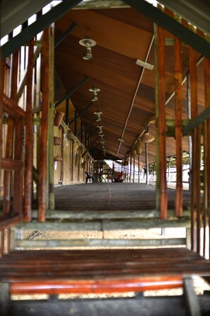 Uma galeria coberta com vigas de madeira e lanternas penduradas.