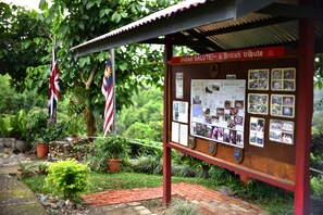 Uma placa histórica com telhado vermelho e uma inscrição com o título 'SABAH SALUTE, uma homenagem britânica'.