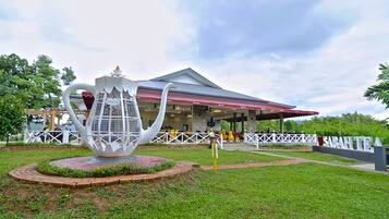 Um edifício com telhado vermelho e uma placa que diz 'SABAH TEA'.