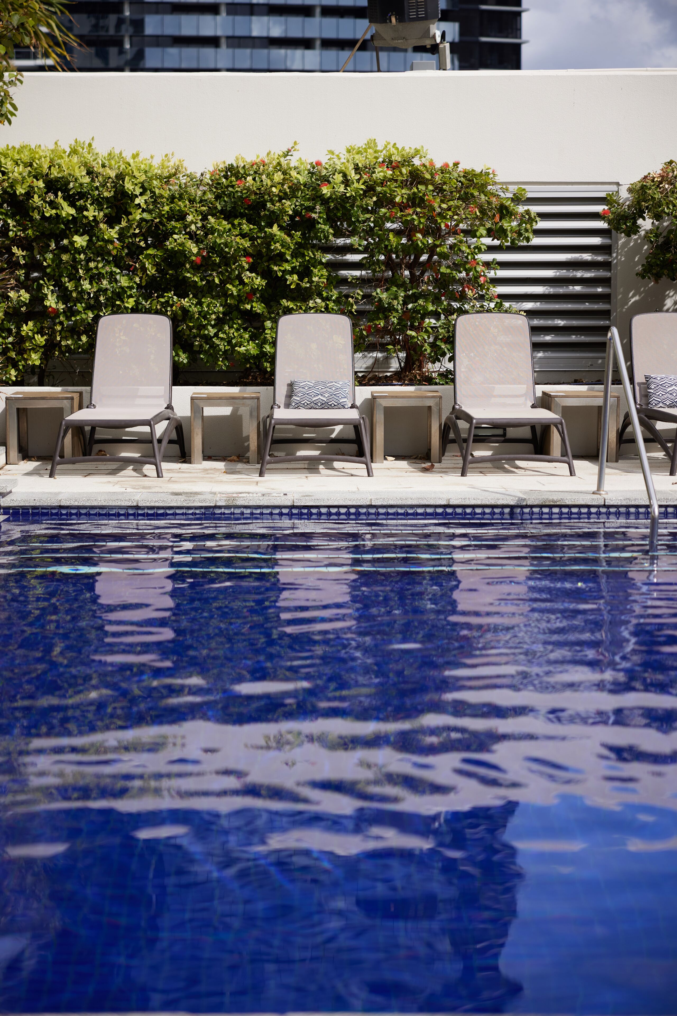 Uma área na beira da piscina com espreguiçadeiras e uma piscina pequena.
