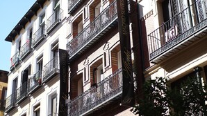 Um edifício de vários andares com varandas e uma placa com a inscrição 'Madrid Suites'.