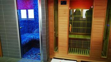 Uma sala de sauna com piso ladrilhado, um banco de madeira e um painel de controle.