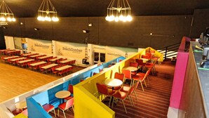 Um restaurante com várias mesas e cadeiras, uma escadaria e vista para a praia.