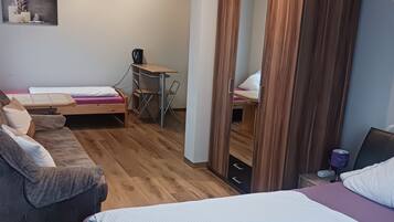 Quarto moderno com cama, sofá, escrivaninha e guarda-roupa.