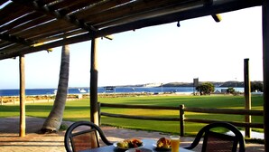 Mesa com itens de café da manhã e vista para um campo de golfe e oceano.