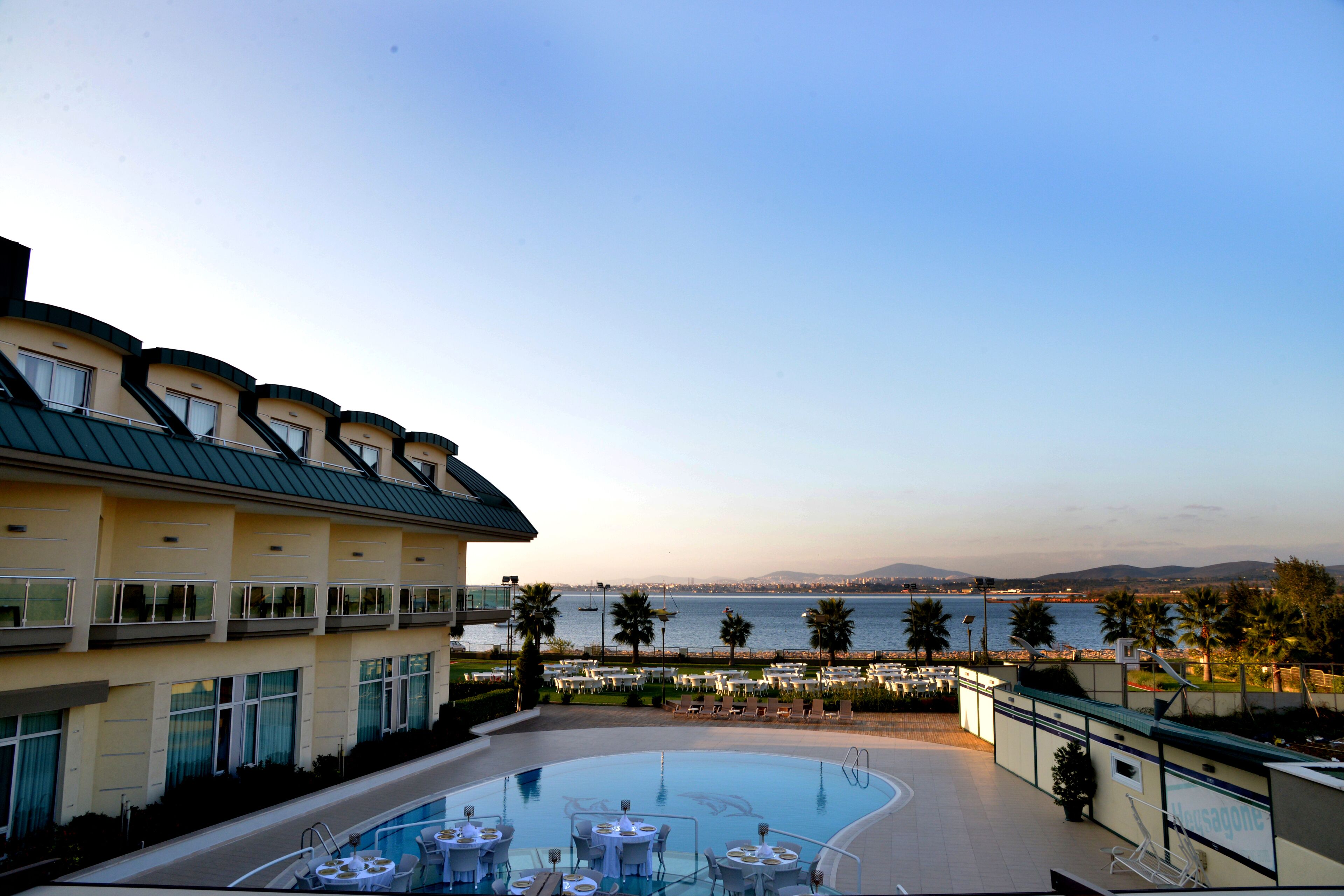 Um hotel com área de piscina, mobiliário de exterior e vista para o mar.