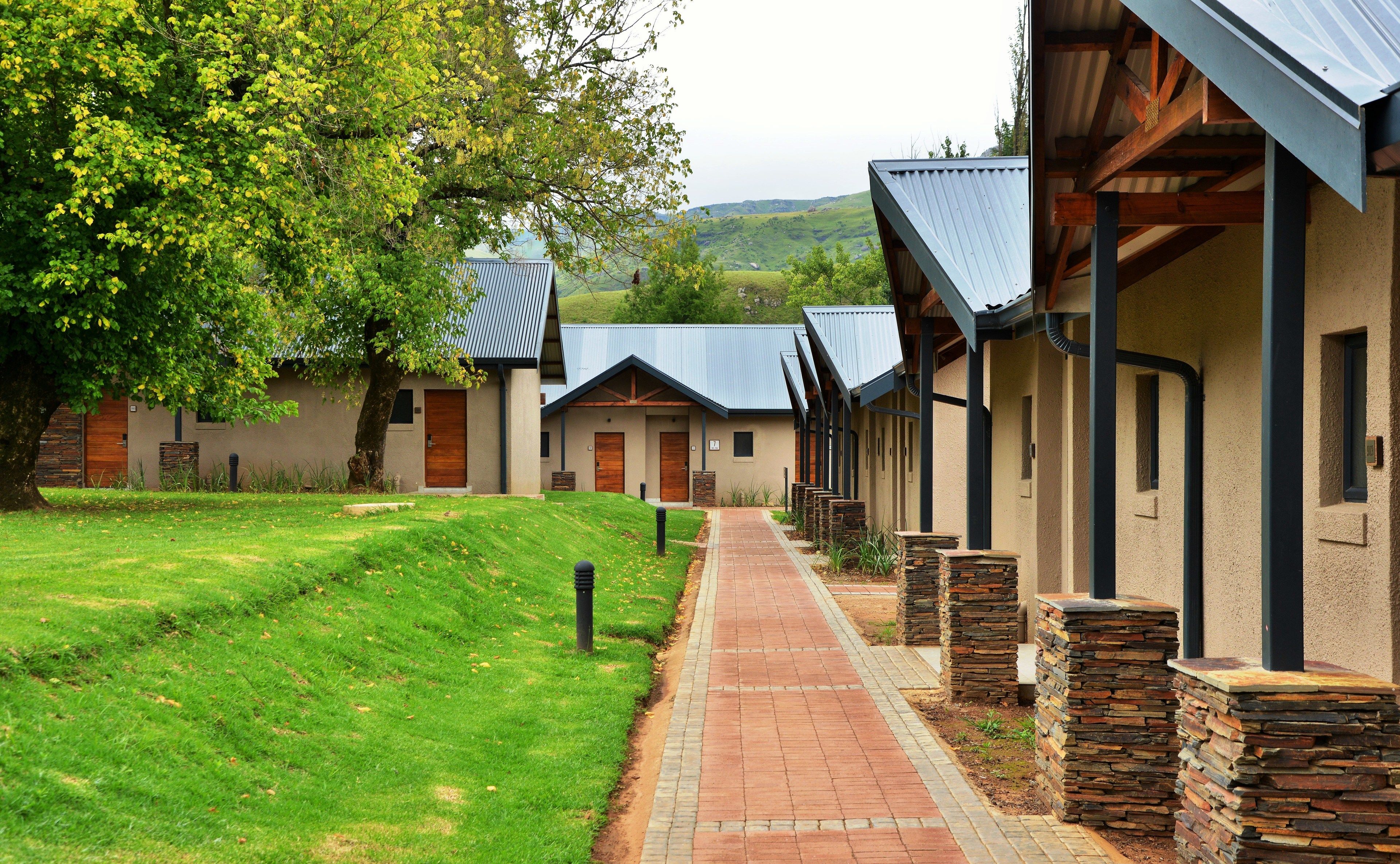 Uma fileira de edifícios modernos, térreos, com um caminho de tijolos levando à entrada.