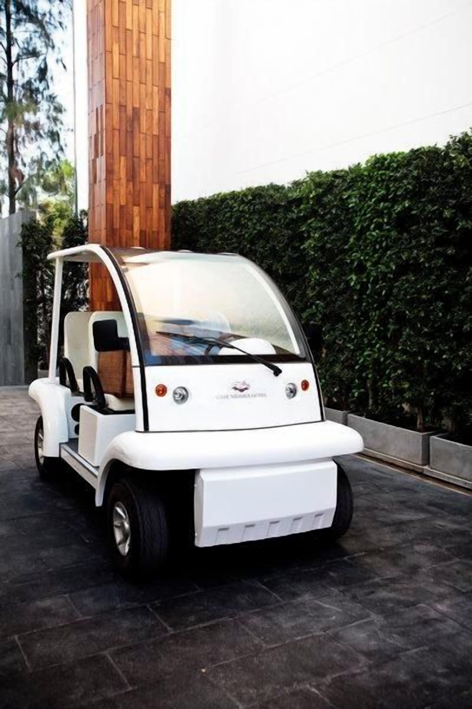 Um veículo branco estacionado em pavimento.