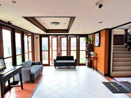 Um hall amplo com um sofá, uma mesa e uma escadaria.