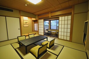 Um quarto japonês tradicional com tatames, uma mesa baixa e biombos shoji.