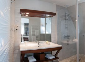 Um secador de cabelo, toalhas fornecidas, sabão, champô 