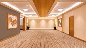 Uma sala de conferências ampla, com carpete estampado, teto de madeira e iluminação embutida.