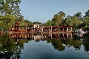 Restaurante à beira do lago com área externa e vista para a água.
