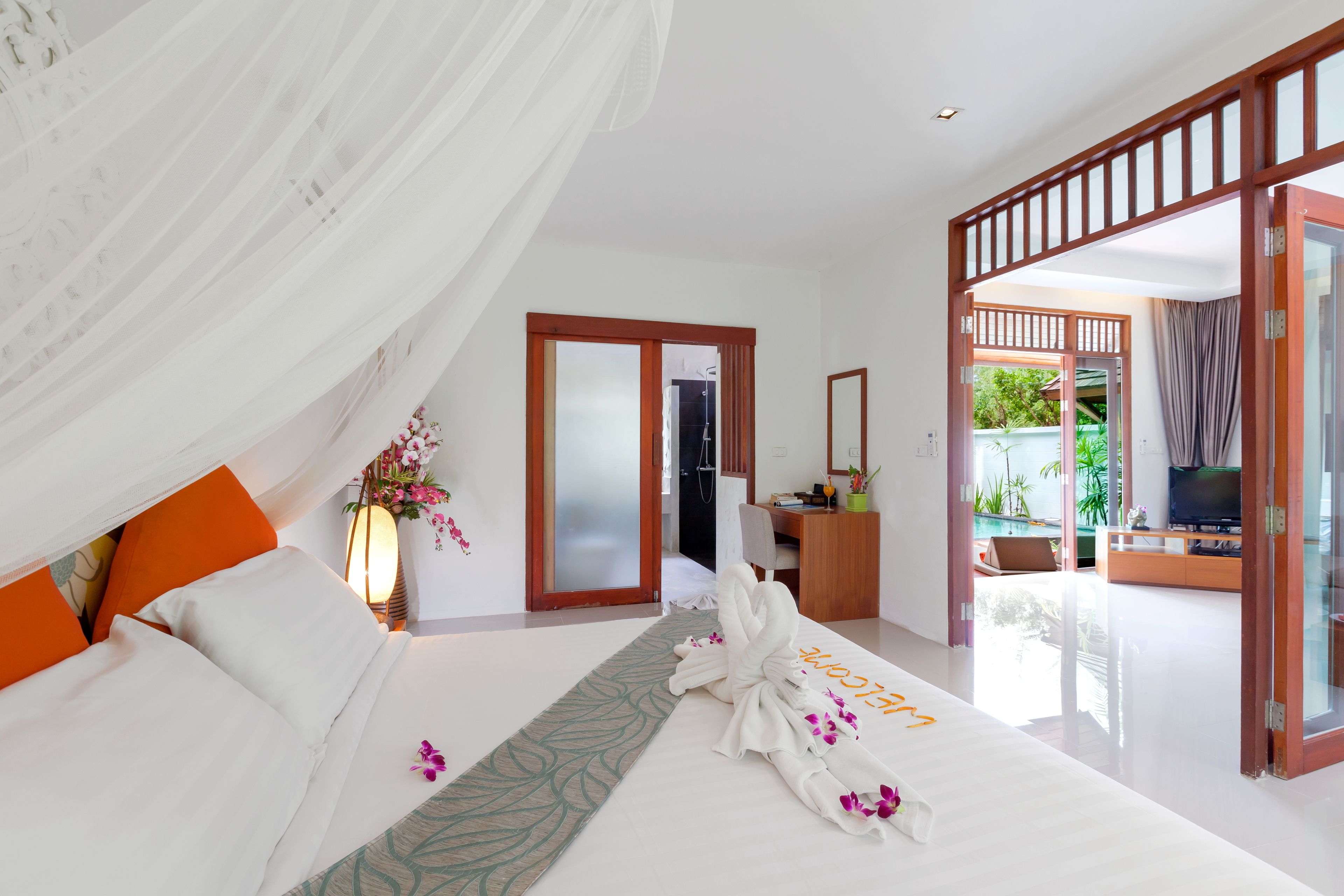 Quarto de hotel moderno com uma cama grande, uma escrivaninha e vista para o exterior.