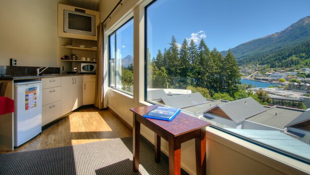 Uma cozinha com vista para uma paisagem montanhosa através de grandes janelas.